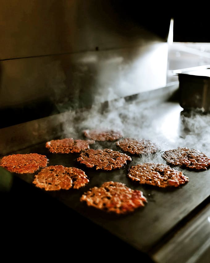 Where the magic happens &ndash; patties sizzle and transform on the flat-top, releasing an aroma that's better than any cologne ever made.