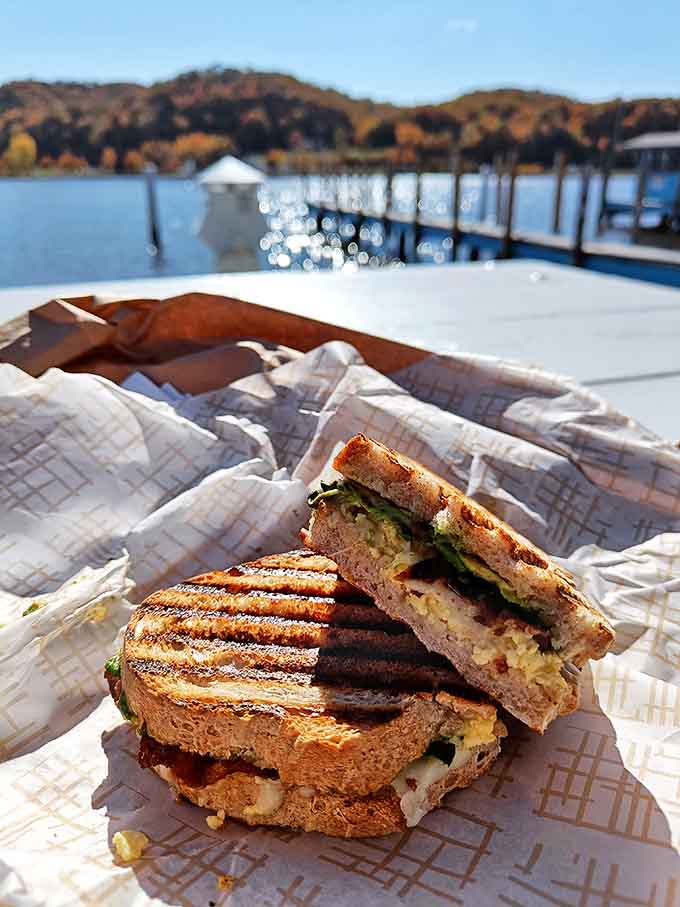 A grilled panini enjoyed with a cold beverage at a colorful table, because lunch should always feel like a mini vacation from reality.