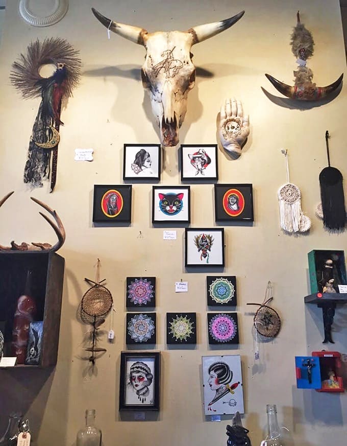 A bovine sentinel watches over an artistic gallery wall, where traditional sugar skull art mingles with contemporary occult-inspired pieces.