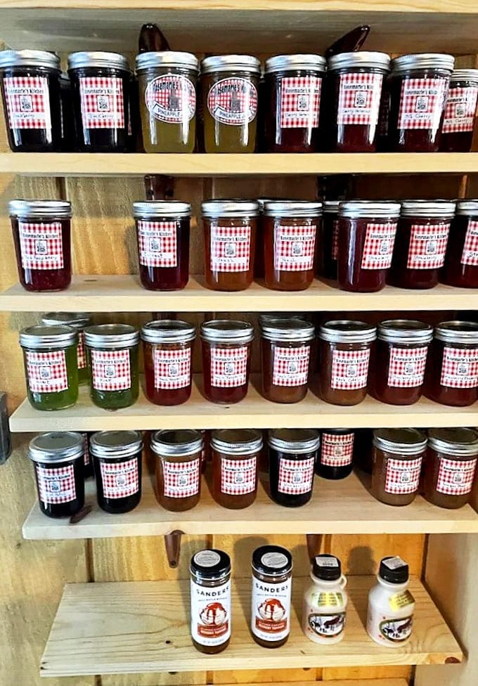 Rows of homemade jams line the shelves like edible jewels, their vibrant colors promising flavors that'll make your morning toast feel like a special occasion.