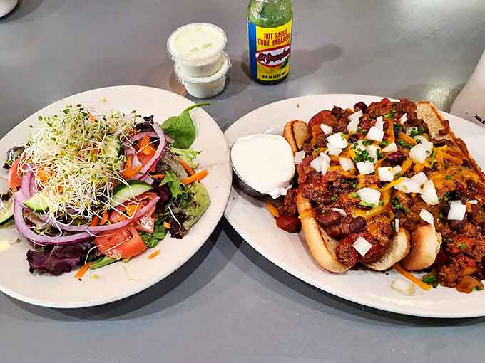 A study in contrasts: fresh, vibrant salad meets hearty, spiced chili dogs, proving Uptown Diner handles lunch with the same flair as their legendary breakfasts.