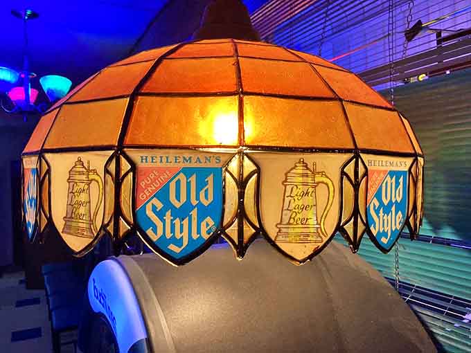 The vintage Old Style lamp illuminates the bar area, a nostalgic reminder of simpler times when beer was cold and pizza was square-cut.