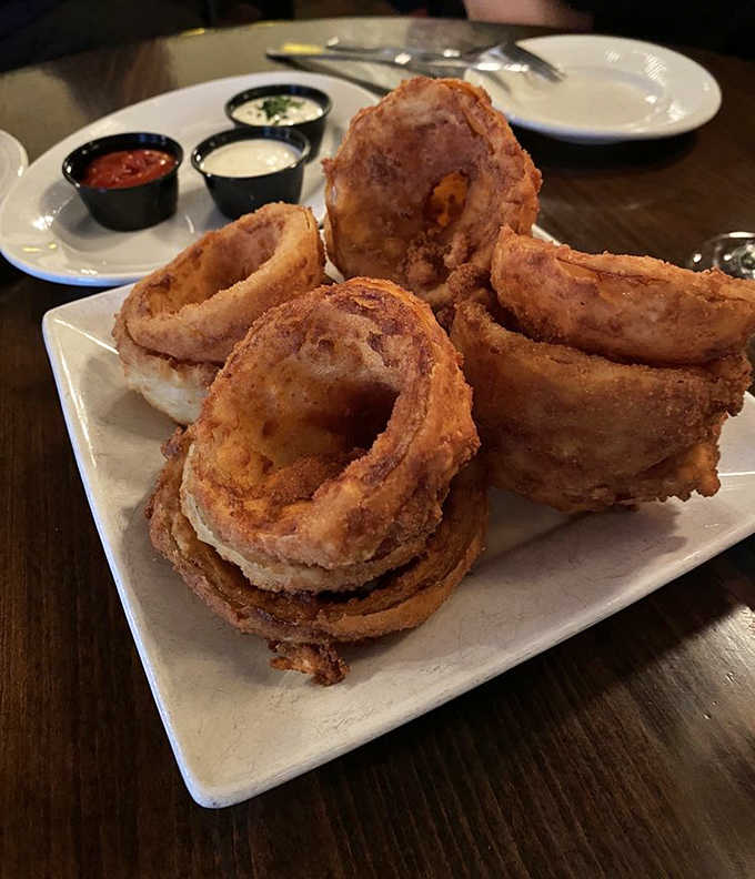 Golden rings of joy stacked high &ndash; crispy exterior giving way to sweet, tender onion within, served with dipping sauces worth fighting over.