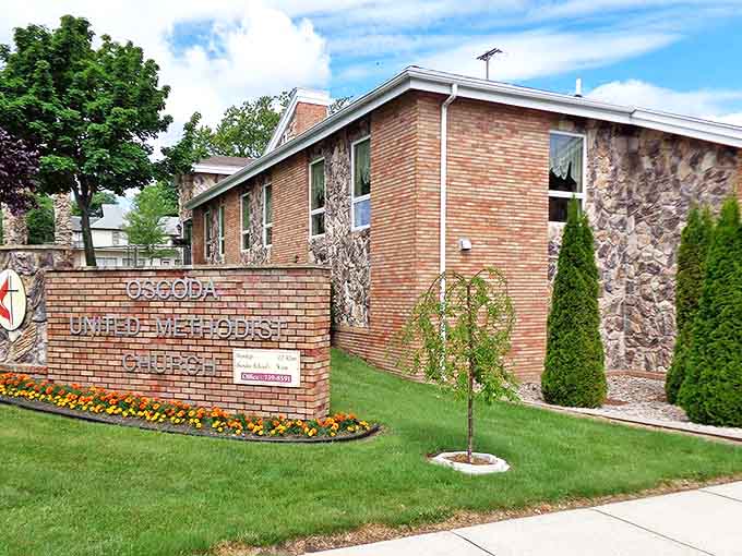 The Oscoda United Methodist Church stands as both spiritual sanctuary and architectural landmark, its stone facade weathered by time and Lake Huron winds.