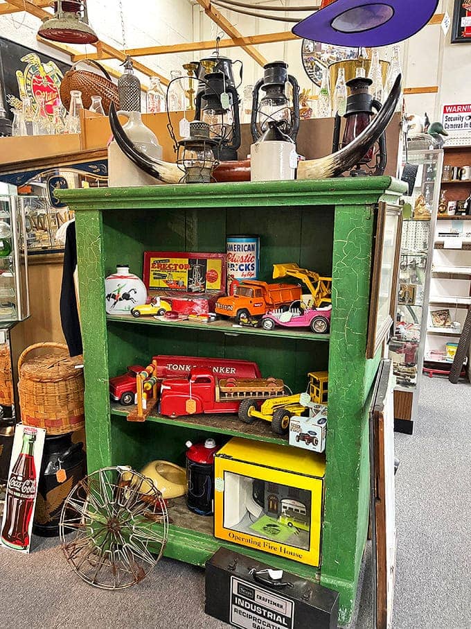 This green cabinet houses childhood dreams from another era – Tonka trucks and vintage playthings that survived decades of imaginative adventures. Built to last, unlike today's plastic.