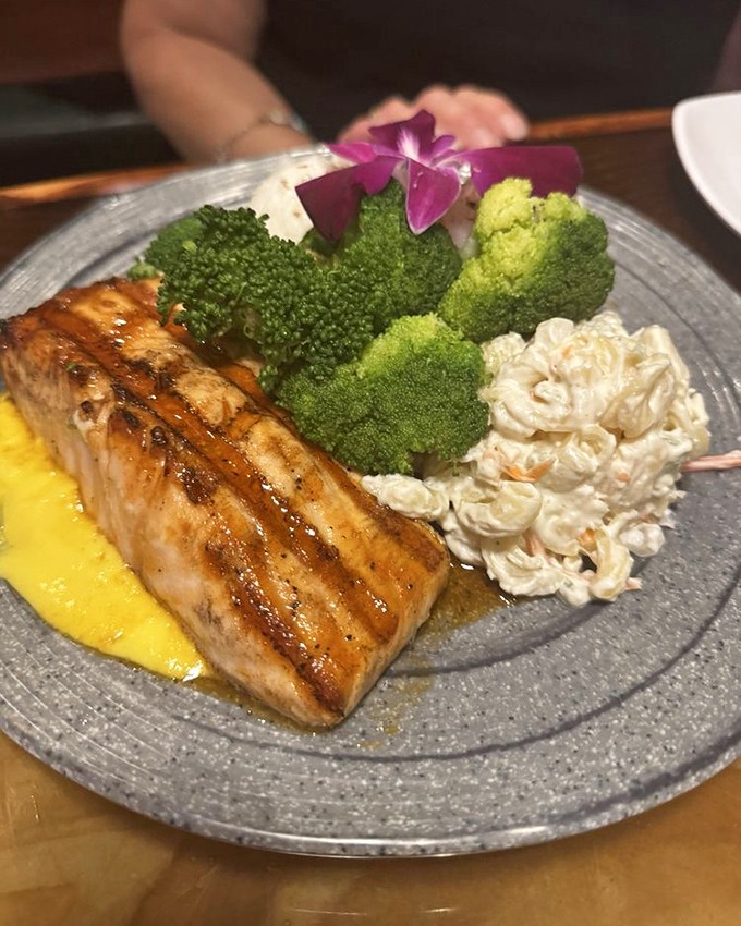 Grilled salmon that glistens like a sunset over Pacific waters, accompanied by vibrant broccoli and creamy macaroni salad.