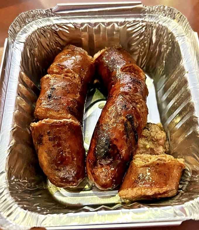 Plump sausages nestled in their foil boat, glistening with juices and promising that perfect snap when bitten into.