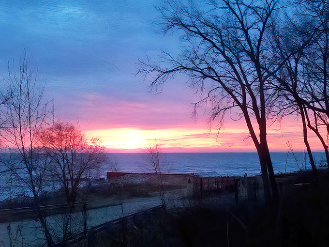 Dawn breaks over Lake Michigan in a spectacular display of pinks and purples, a daily performance that never fails to impress.