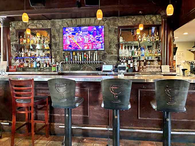 The welcoming bar area, with its impressive array of spirits against a rustic stone backdrop, offers the perfect spot to sample Michigan's thriving craft beer scene.