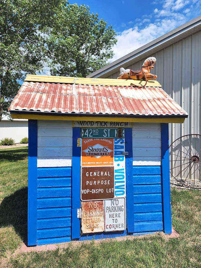 Bold blue paint and vintage signage make this outhouse pop against the green lawn &ndash; "School Crossing" indeed!