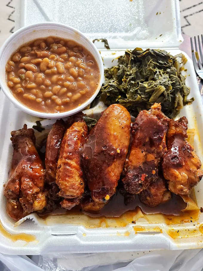 Chicken wings and sides nestled in their takeout container like a barbecue treasure chest waiting to be discovered.