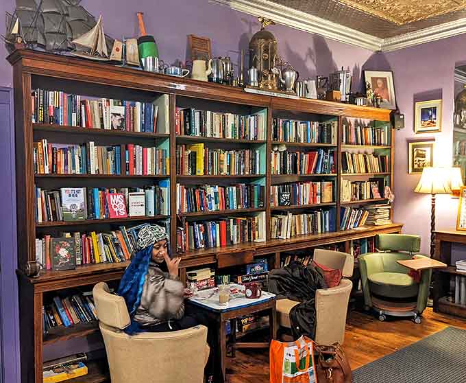 Books, comfy chairs, and purple walls create the kind of cozy corner where time moves differently, usually much slower and more pleasantly.