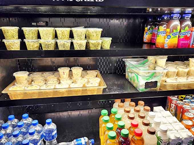 The display case showcases a rainbow of frozen possibilities, each tub containing someone's moment of pure, uncomplicated happiness.