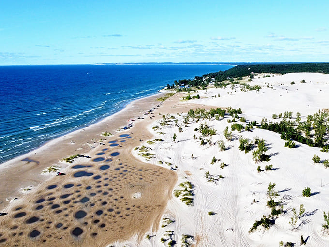 Aerial view reveals the magnificent scale of Silver Lake's dune system, where golden sand mountains create a desert-like landscape alongside the freshwater sea.
