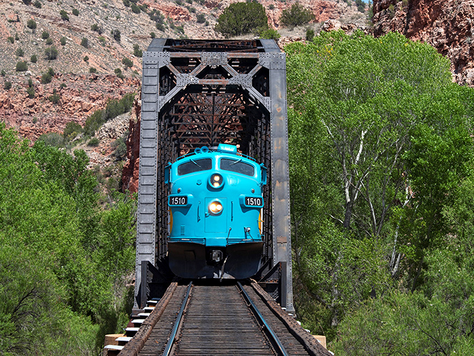 Like threading a needle made of stone, the turquoise train emerges from the tunnel, a perfect photo opportunity that captures Arizona's dramatic contrasts.