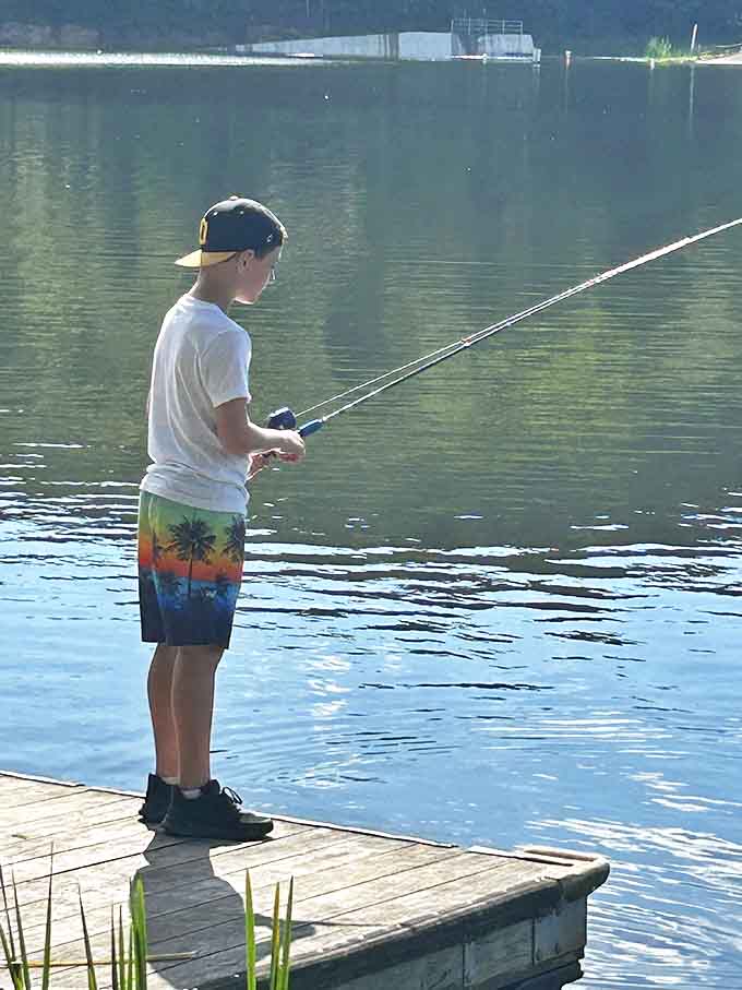 A young angler tries his luck from the dock, learning the timeless lesson that fishing is about patience, hope, and enjoying the wait.