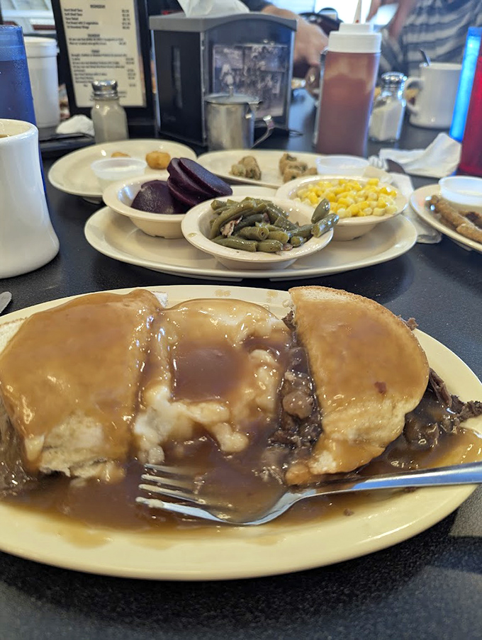 Hot roast beef sandwich swimming in gravy – the kind of honest, unpretentious plate that makes fancy food seem unnecessarily complicated.