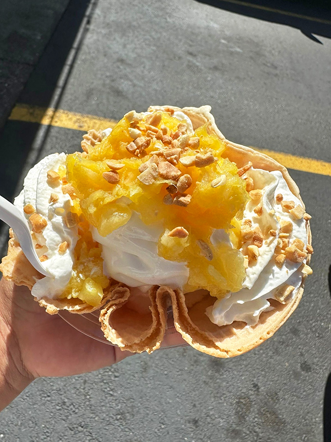 Pineapple paradise in a waffle bowl – golden fruit chunks nestled in vanilla soft serve, topped with whipped cream and crunchy nuts.