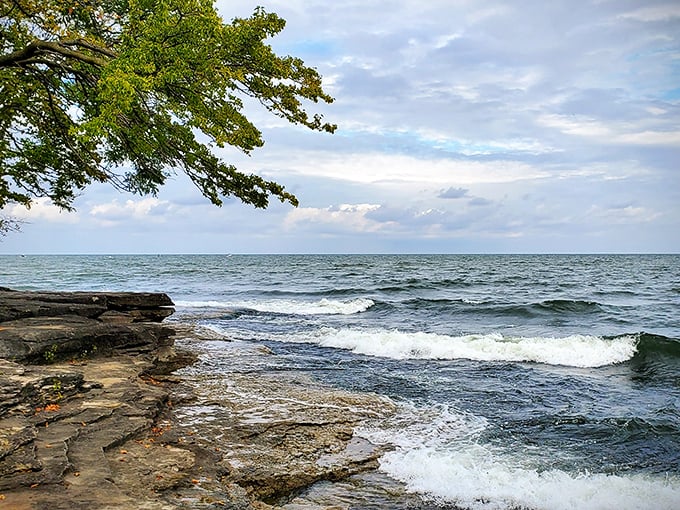 Lake Erie shows its moody side as waves crash against the rocky shore – a reminder of why this lighthouse has been so crucial to generations of sailors.