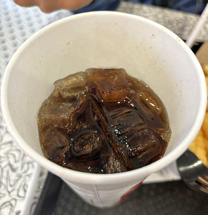 Even the soda tastes better here, served in those perfectly sized paper cups that somehow make every sip more refreshing than the last.
