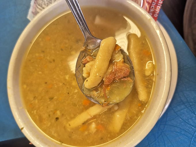 Chicken noodle soup with thick, hearty noodles swimming in golden broth &ndash; grandmother-approved comfort in every steaming spoonful.