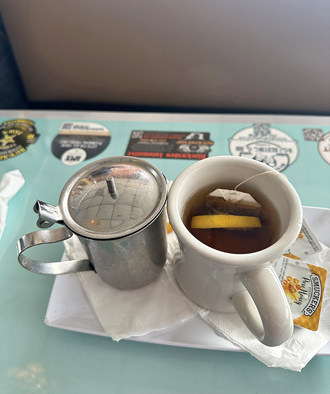 Hot tea served the right way&mdash;with a personal pot and lemon slice. The mug practically whispers, "Take a moment, friend. The world can wait."