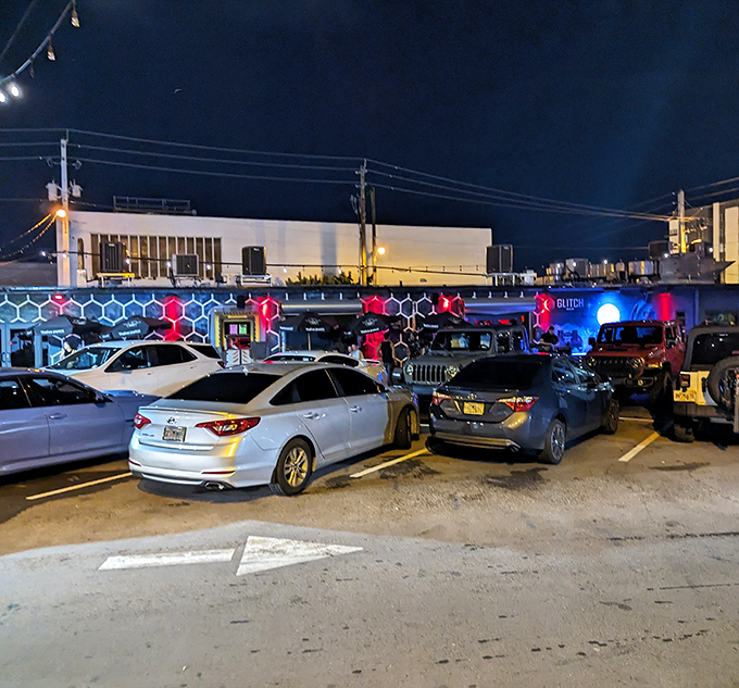 The parking area fills up as night falls, with patrons arriving for an evening where adult beverages meet childhood gaming obsessions.