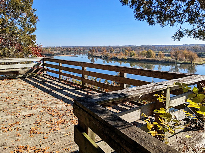 A rustic wooden fence frames the spectacular river view, providing both safety and a perfect spot for contemplation.