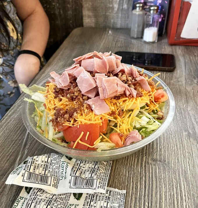 Even the salads refuse to be dainty &ndash; a hearty bowl loaded with fresh vegetables, cheese, and ham that laughs in the face of "diet food."