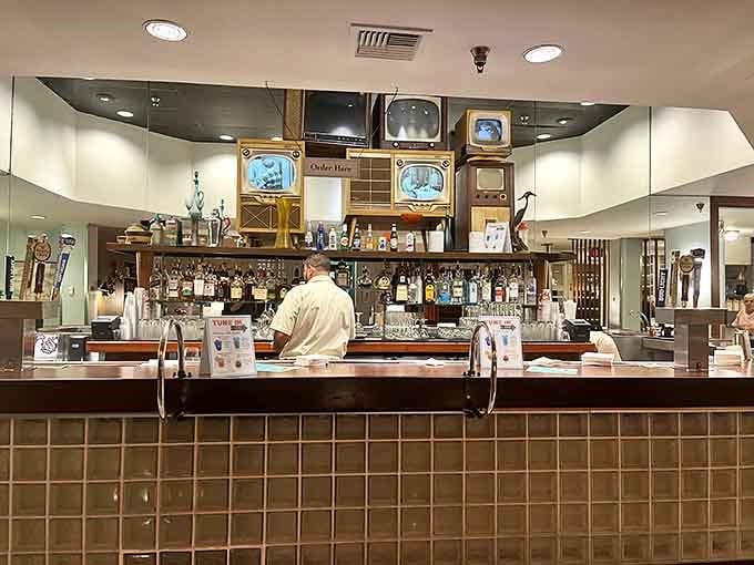 The bar area features vintage televisions playing classic shows, making even waiting for your table part of the immersive experience.