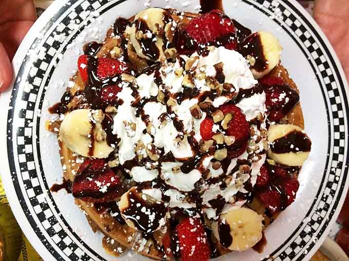 This waffle doesn't just have toppings &ndash; it has an entire fruit salad, chocolate sauce, and whipped cream performing a circus act.