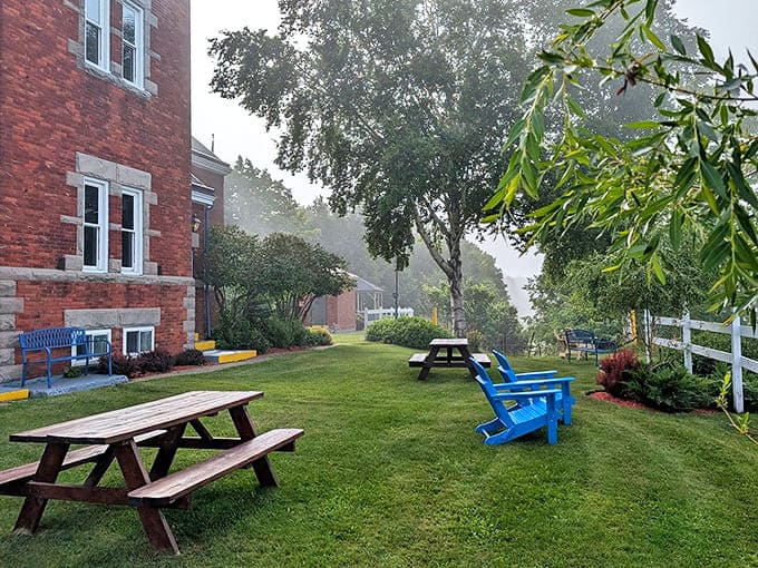 Morning mist creates a dreamy atmosphere around the picnic area, where wooden tables await guests seeking an outdoor breakfast experience.