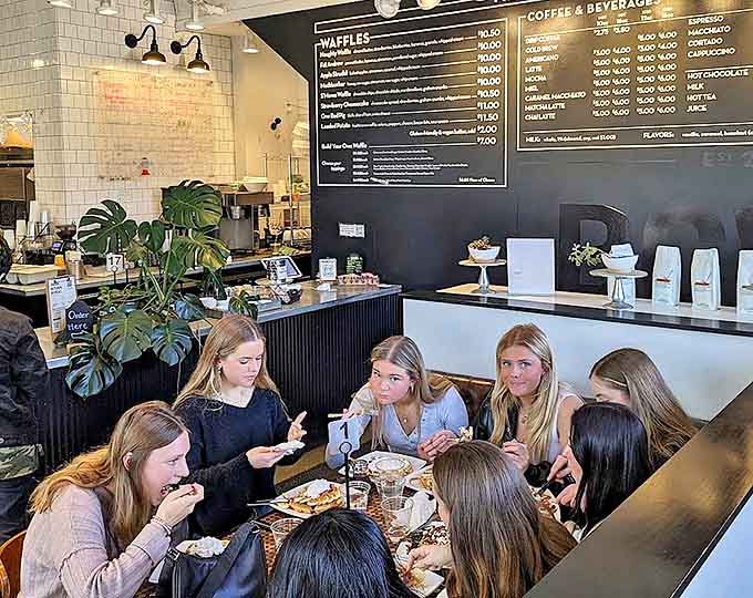 A gathering of waffle enthusiasts enjoying their breakfast treasures, creating that perfect buzz of satisfied conversation.