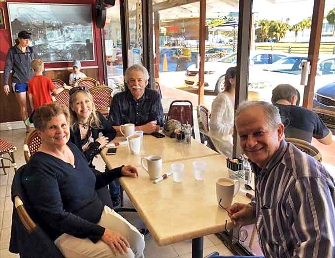 Happy patrons enjoying the simple pleasure of good food and conversation &ndash; the universal language of caf&eacute; culture.
