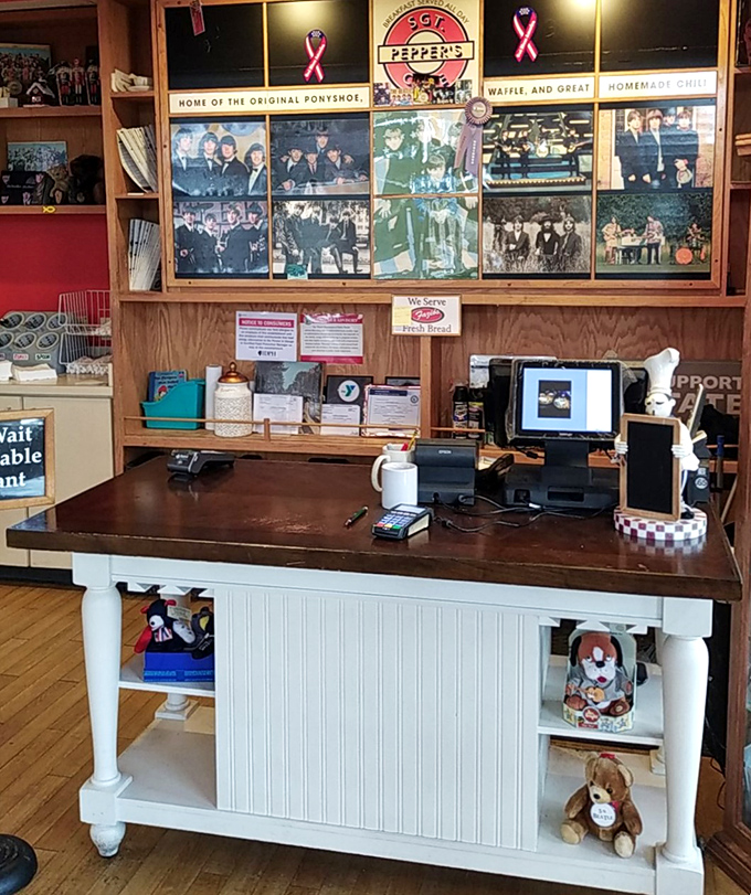 The heart of operations, where friendly staff orchestrate the daily symphony of food and service beneath a gallery of Beatles memories.