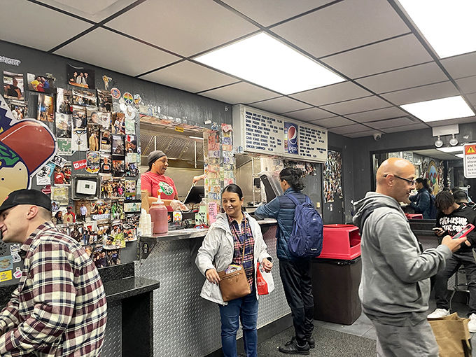 The bustling counter area where the magic happens &ndash; customers placing orders while staff prepare Chicago's favorite street food with practiced efficiency.