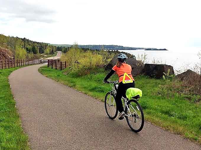The gentle curve of the shoreline trail invites cyclists to discover what lies around the next bend.