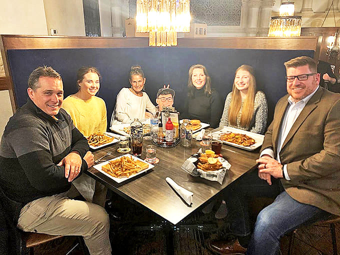 A gathering of food enthusiasts enjoying the universal religion of good company and better meals in this converted sanctuary.