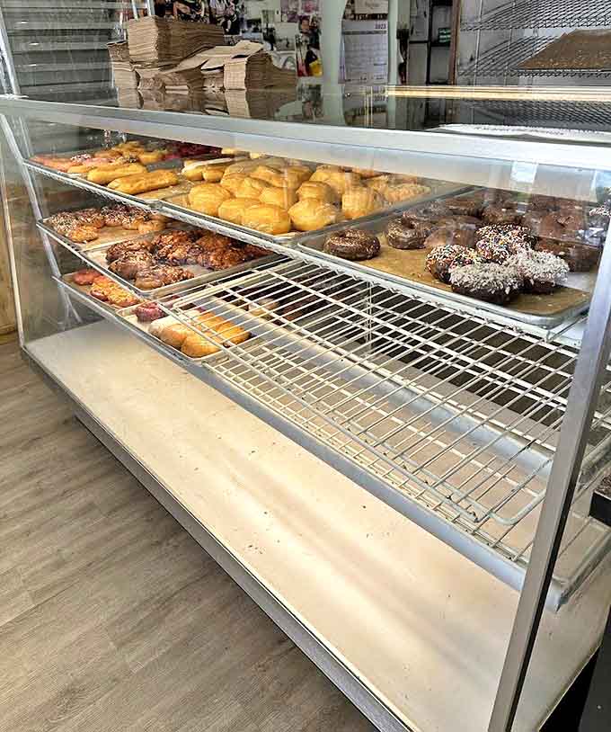 The glass case of temptation where diet plans go to die &ndash; each shelf a new opportunity for delicious morning decisions.