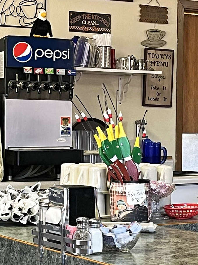 The service counter tells stories of thousands of meals served, with fishing bobbers and coffee mugs standing ready for the next hungry traveler.