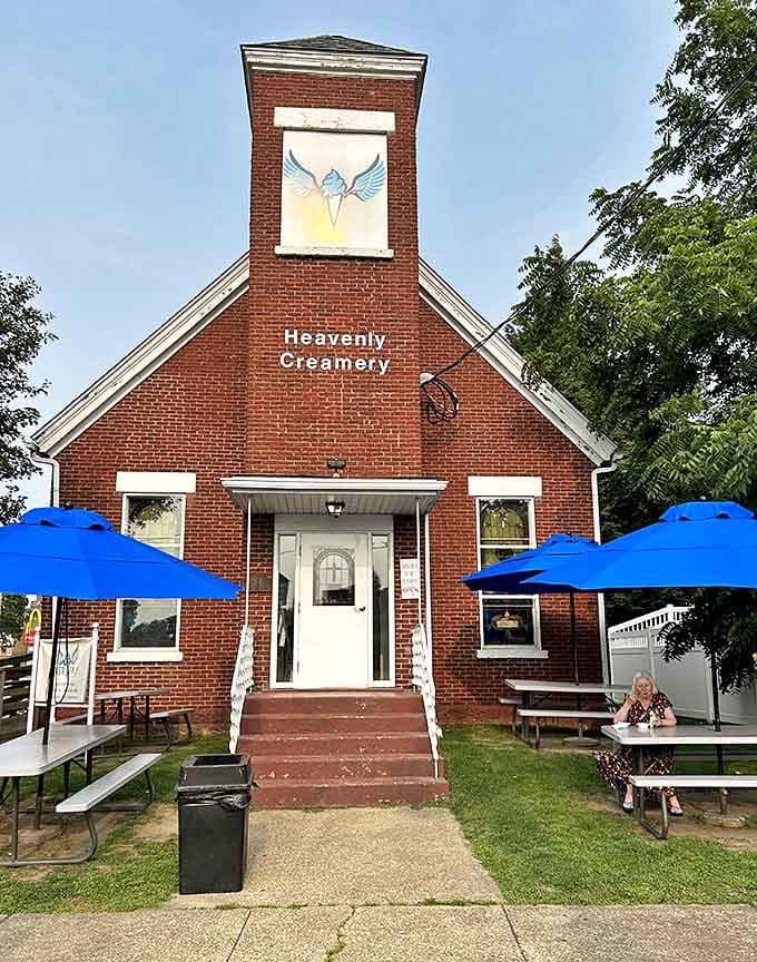 Heavenly Creamery welcomes pilgrims seeking sweet salvation. Blue umbrellas shade outdoor tables where ice cream devotees worship at the altar of frozen delights.