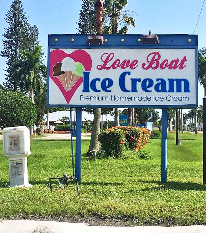 The roadside sign stands as a sweet landmark, guiding ice cream pilgrims to their creamy destination under swaying Florida palms.