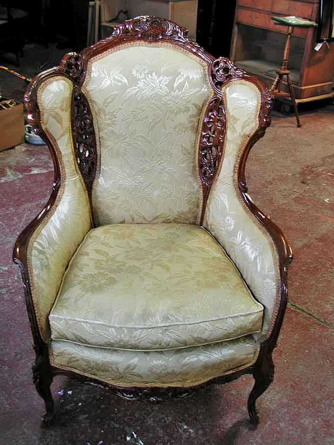 This Victorian armchair doesn't just offer a seat – it provides a throne, with its ornate carved wood and sumptuous cream damask upholstery.