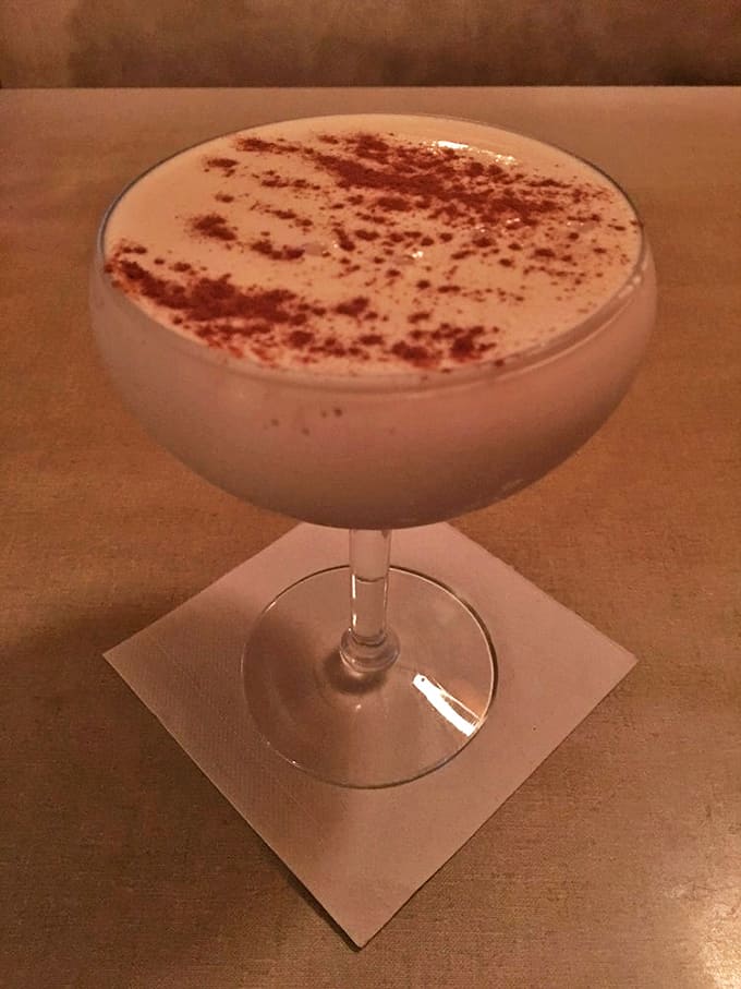 This signature libation arrives like a cloud in a glass, dusted with cinnamon and promising a perfect prelude to dinner.