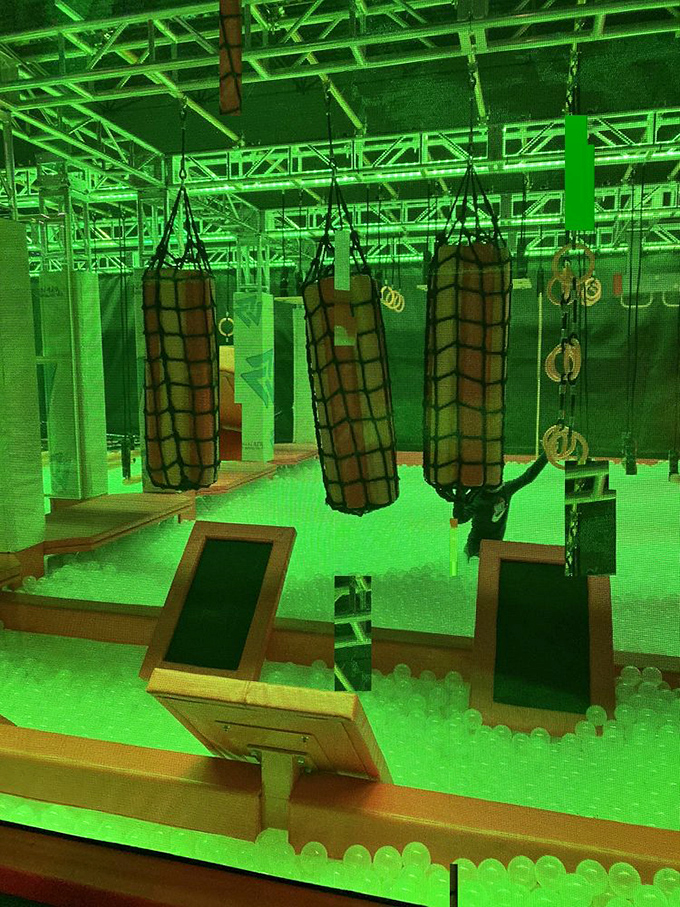 That obstacle course glows green like it's radioactive, which feels appropriate given how it'll mutate your muscles into jelly by tomorrow morning.