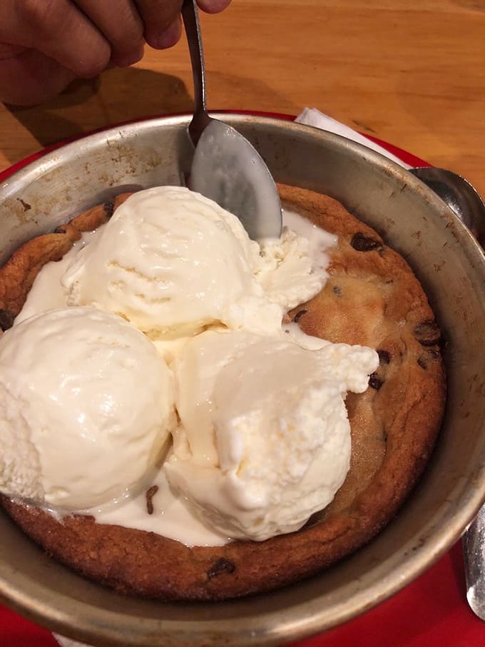 A pizzookie arrives like dessert destiny, warm cookie dough topped with ice cream that melts into pure happiness.