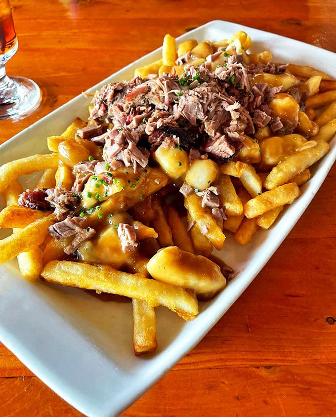 Poutine elevated to art form &ndash; golden fries swimming in gravy, crowned with tender brisket that makes this Canadian classic even more indulgent.