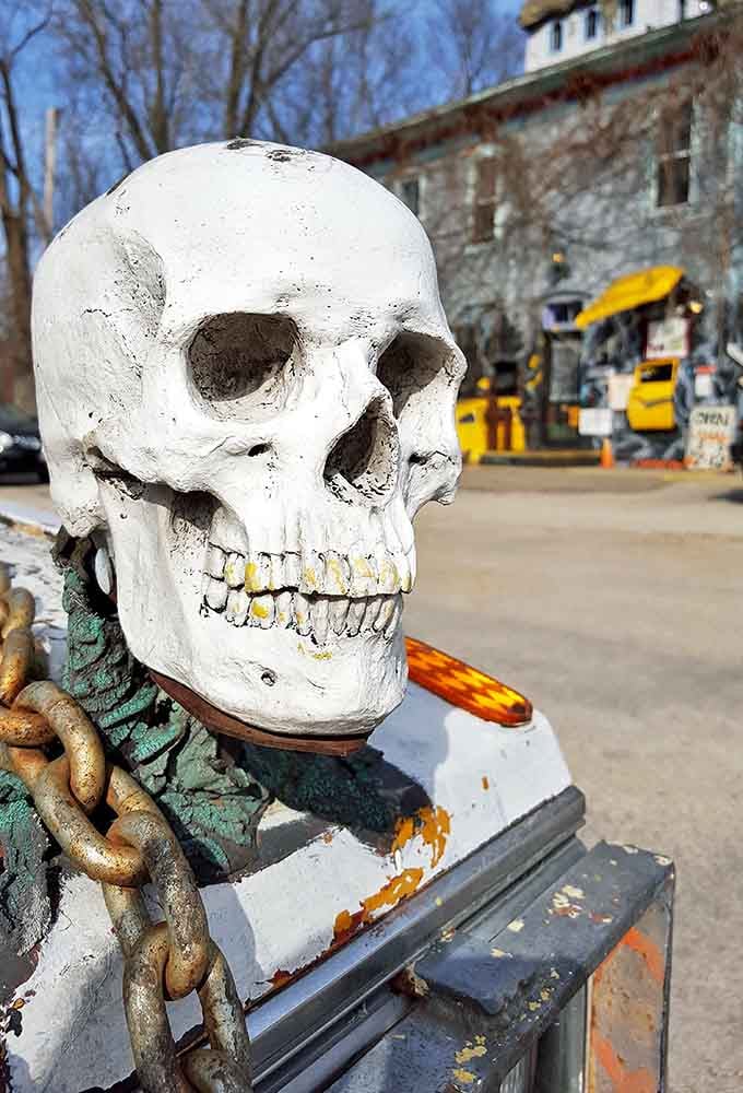 A grinning sentinel guards the approach to the main building, its weathered teeth catching the sunlight in an almost friendly grimace.