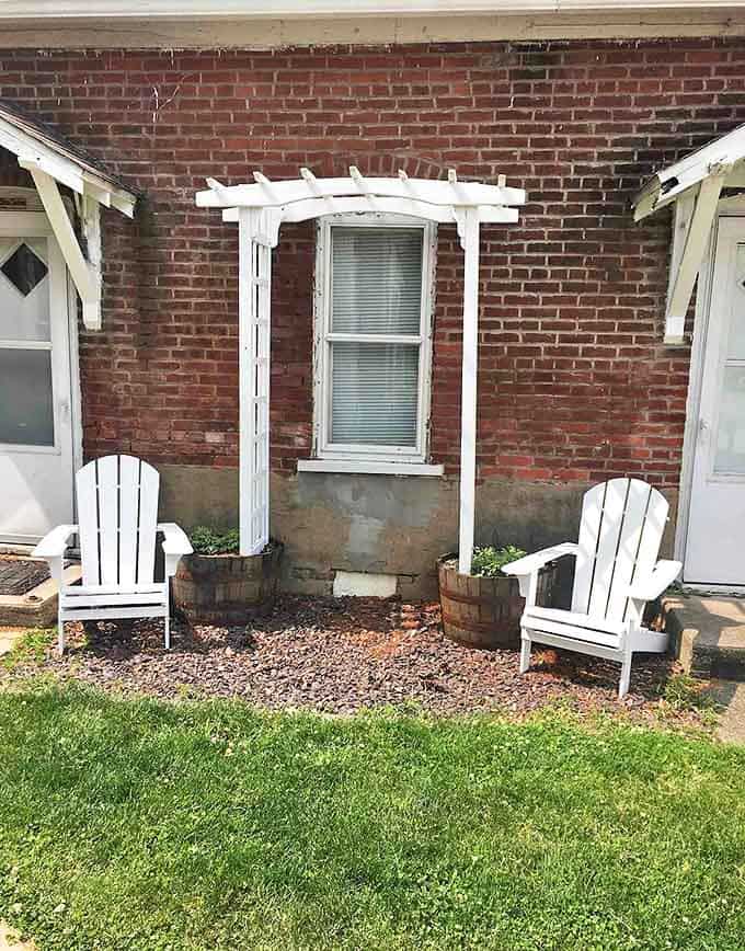 White Adirondack chairs offer front-row seats to nature's daily performance &ndash; from morning birdsong to evening fireflies.