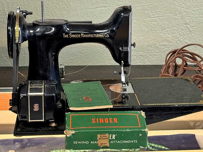 A Singer sewing machine that probably stitched together more clothes than a modern fast-fashion factory, back when "homemade" meant quality, not compromise.